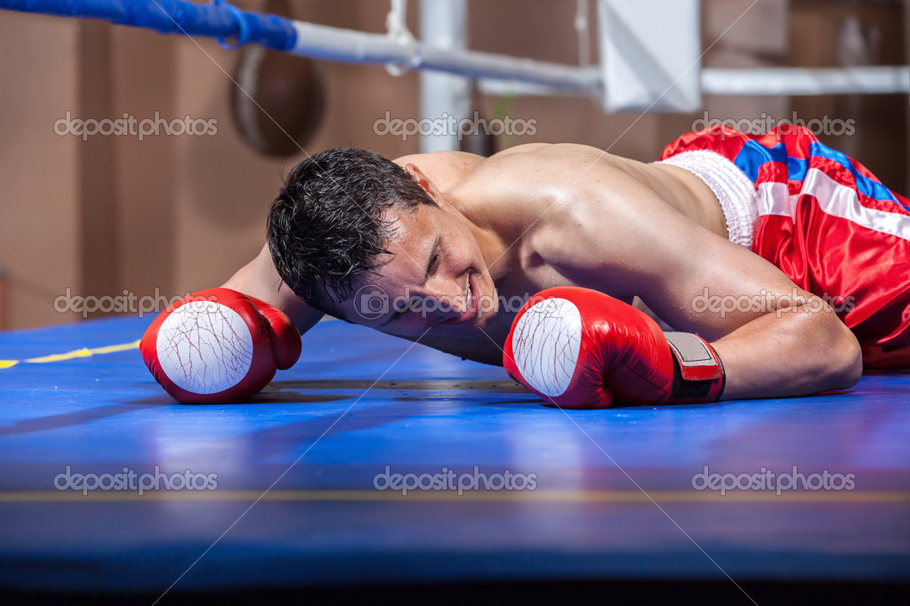 Boxer lying knocked out in a boxing ring — Stock Photo © anpet2000 ...