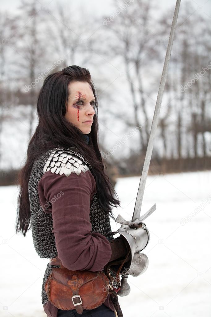 Beautiful young woman in medieval clothes holding a sword Stock Photo ...