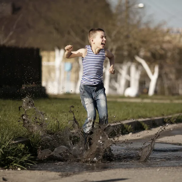 Little boy jumping in puddle Stock Photo by ©ababaka 42849273