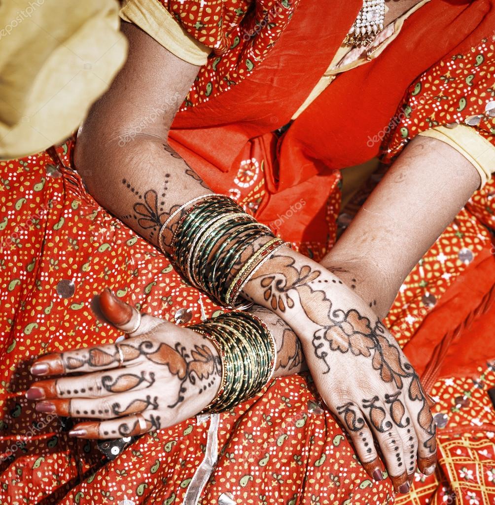 Hands of a young Indian woman adorned with traditional bangles and ...