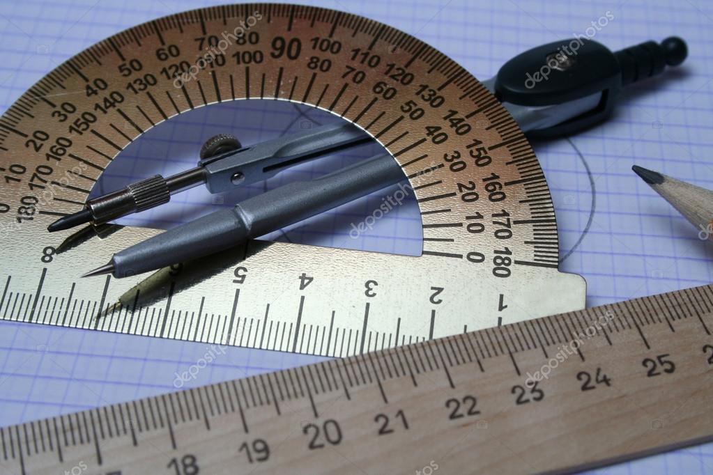 Compasses, pencil and ruler on squared paper — Stock Photo © parrus ...