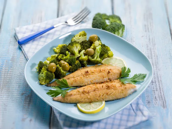 Breaded fish with broccoli and olives, selective focus - Stock Image ...