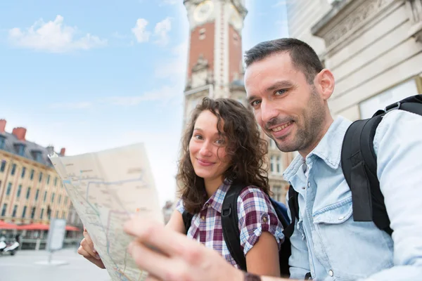 Couple of young attractive tourists watching map - Stock Image - Everypixel
