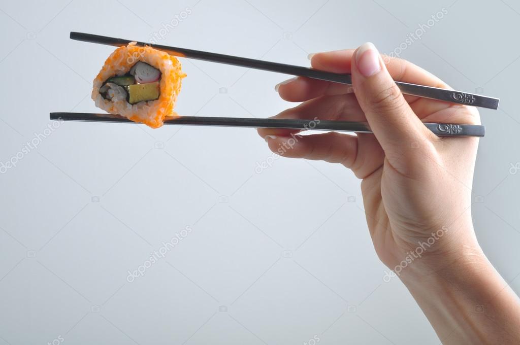 Hand with chopstick holding sushi Stock Photo by ©yuliang11 12210873