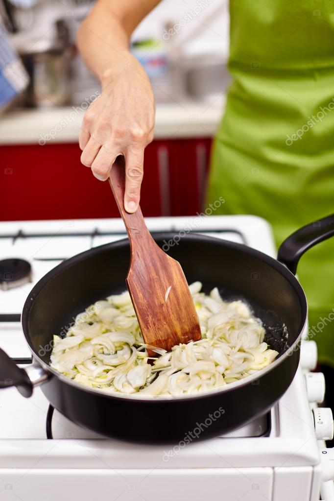 Stirring onion in the pan Stock Photo by ©Xalanx 40174137
