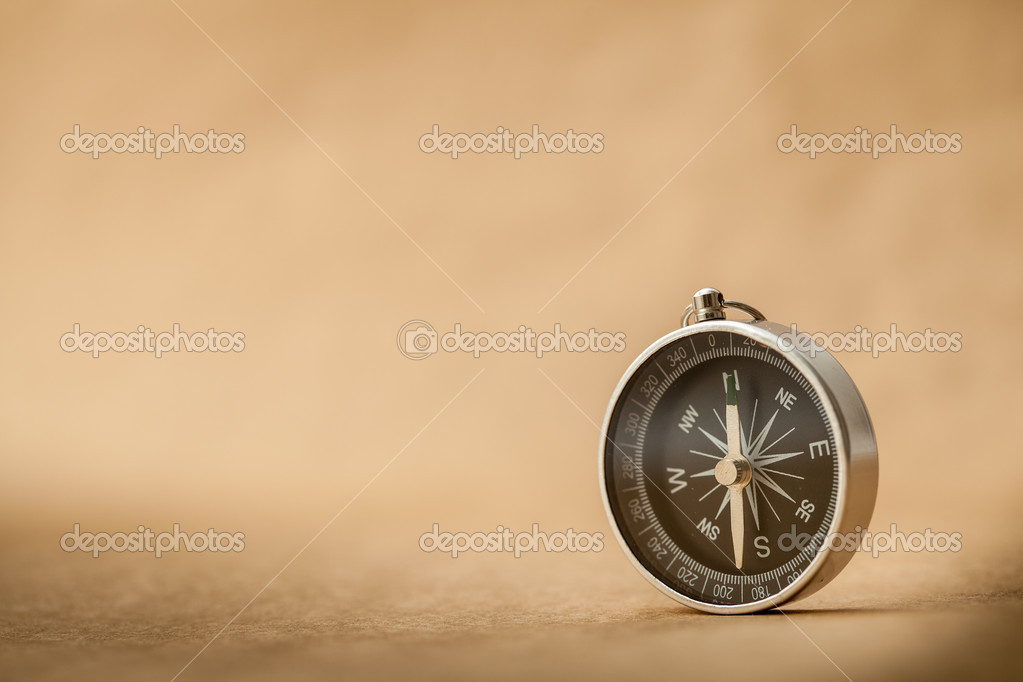 Compass on Light Brown Background Stock Photo by ©DWiedemann 24669007