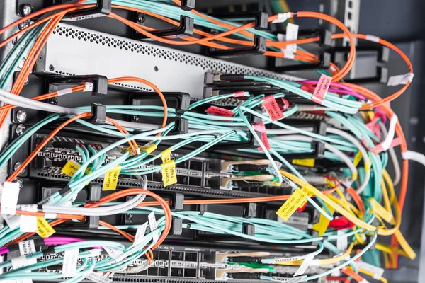 detail of server rack with fiber optic cables attached to front panel ...