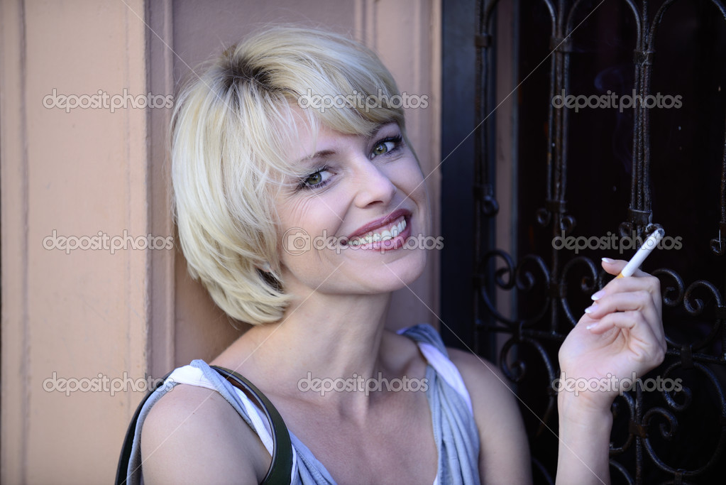 Happy woman smoking a cigarette Stock Photo by ©mangostock 12296266