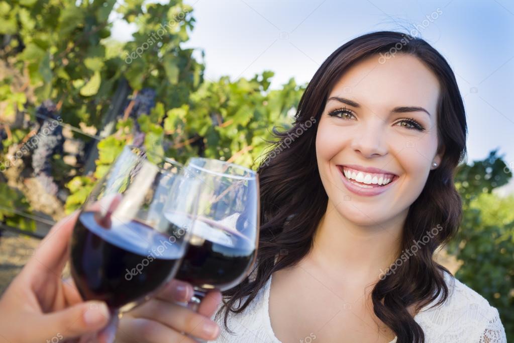 Young Woman Enjoying Glass Of Wine In Vineyard With Friends ⬇ Stock