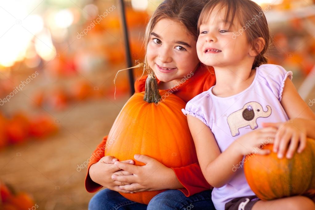 Cute Little Girls Holding Their Pumpkins At A Pumpkin Patch Stock Photo ...