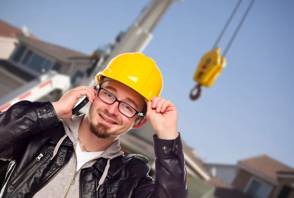 Young Construction Worker on Cell Phone In Front of Crane - Stock Image ...