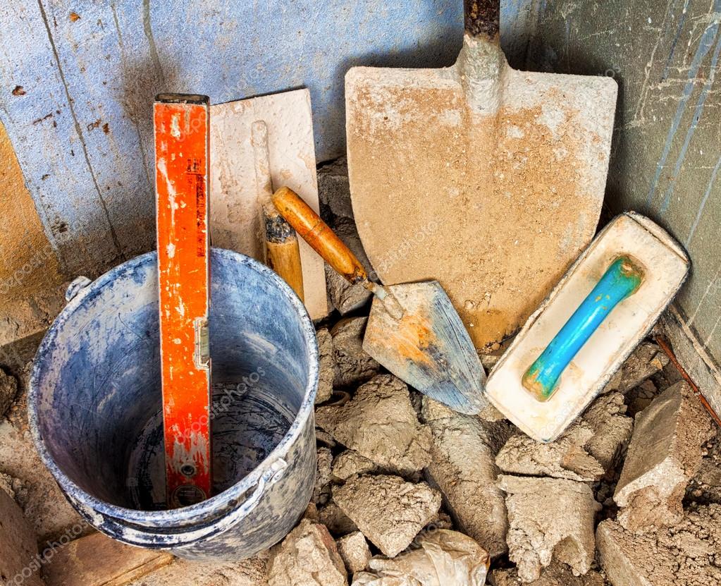 Masonry tools in the corner of an unfinished concrete wall — Stock ...