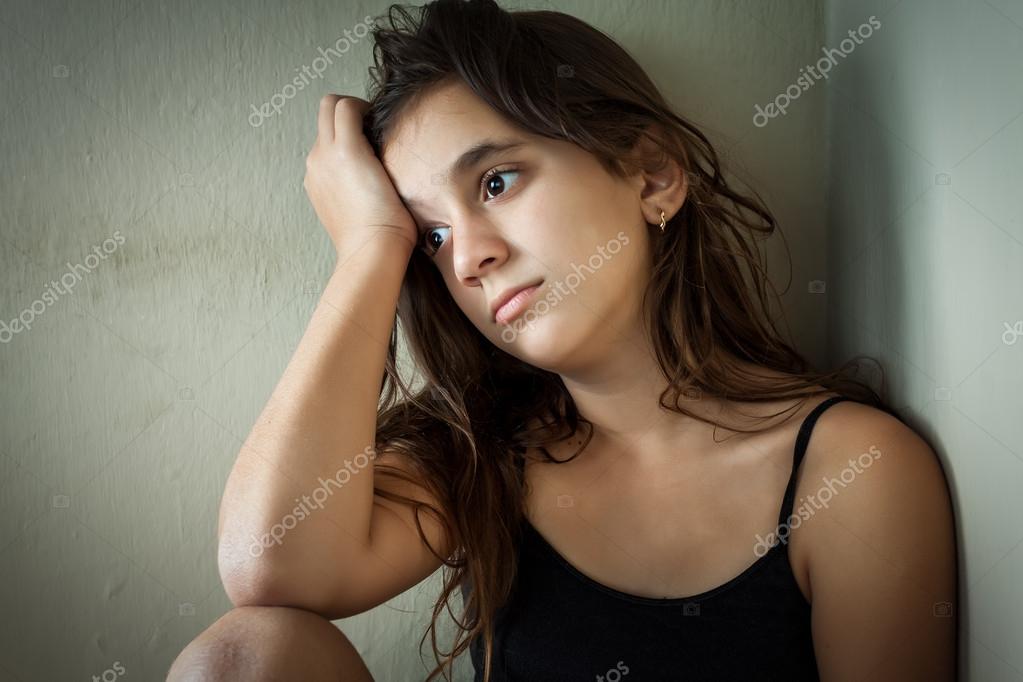 Sad hispanic girl sitting in a corner Stock Photo by ©kmiragaya 16501341