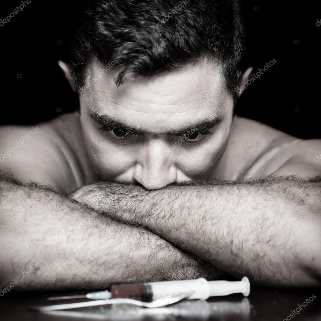 Depressed drug addict and a syringe Stock Photo by ©kmiragaya 31569741