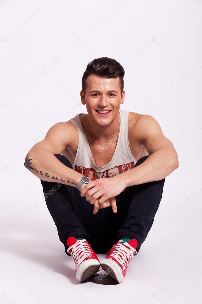 Muscular man sitting & smiling to camera Stock Photo by ©feedough 19117313