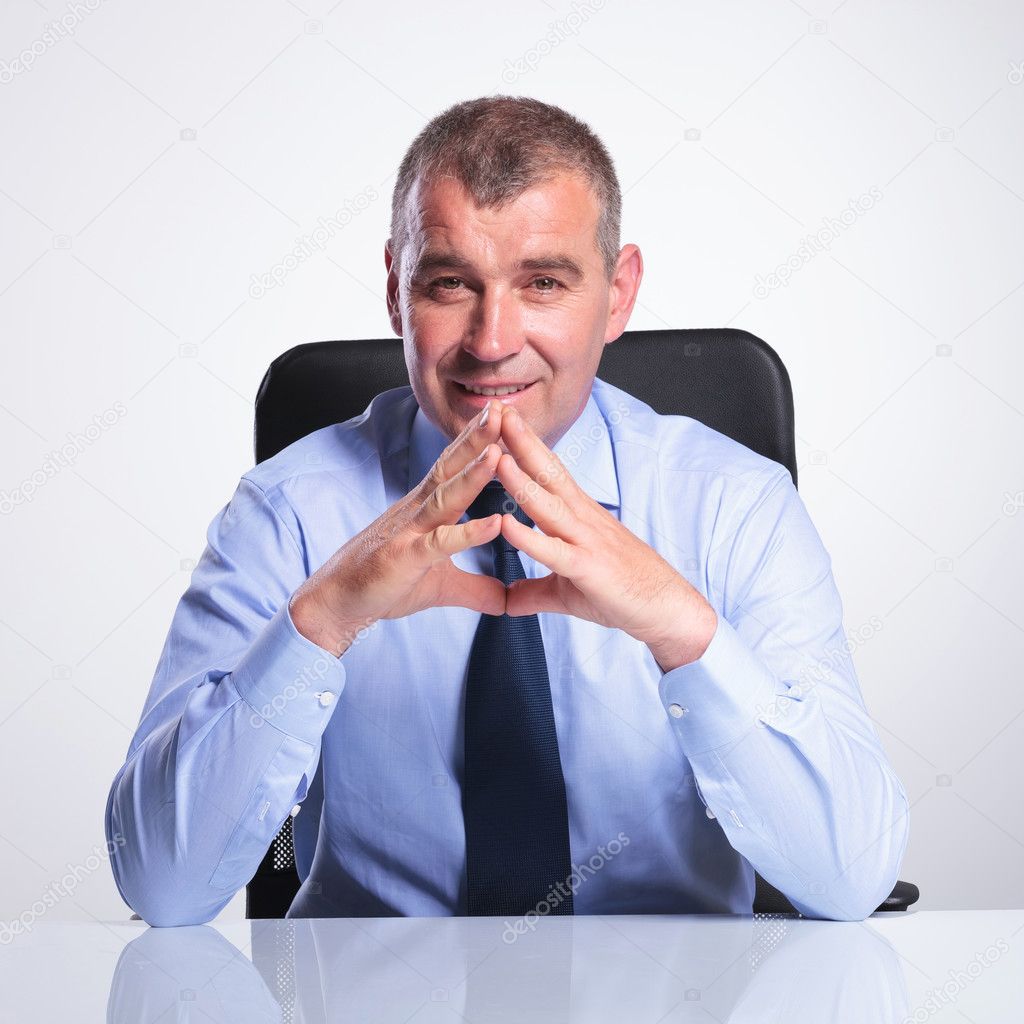 Old business man at desk with hands together Stock Photo by ©feedough ...