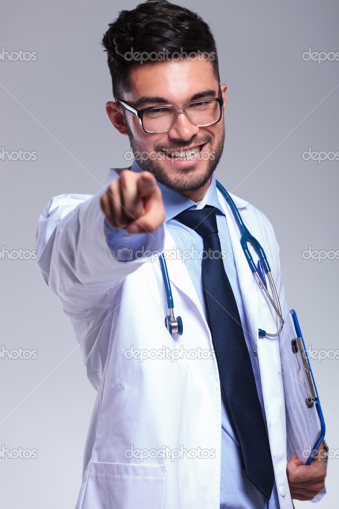 Young doctor with clipboard pointing at you — Stock Photo © feedough ...