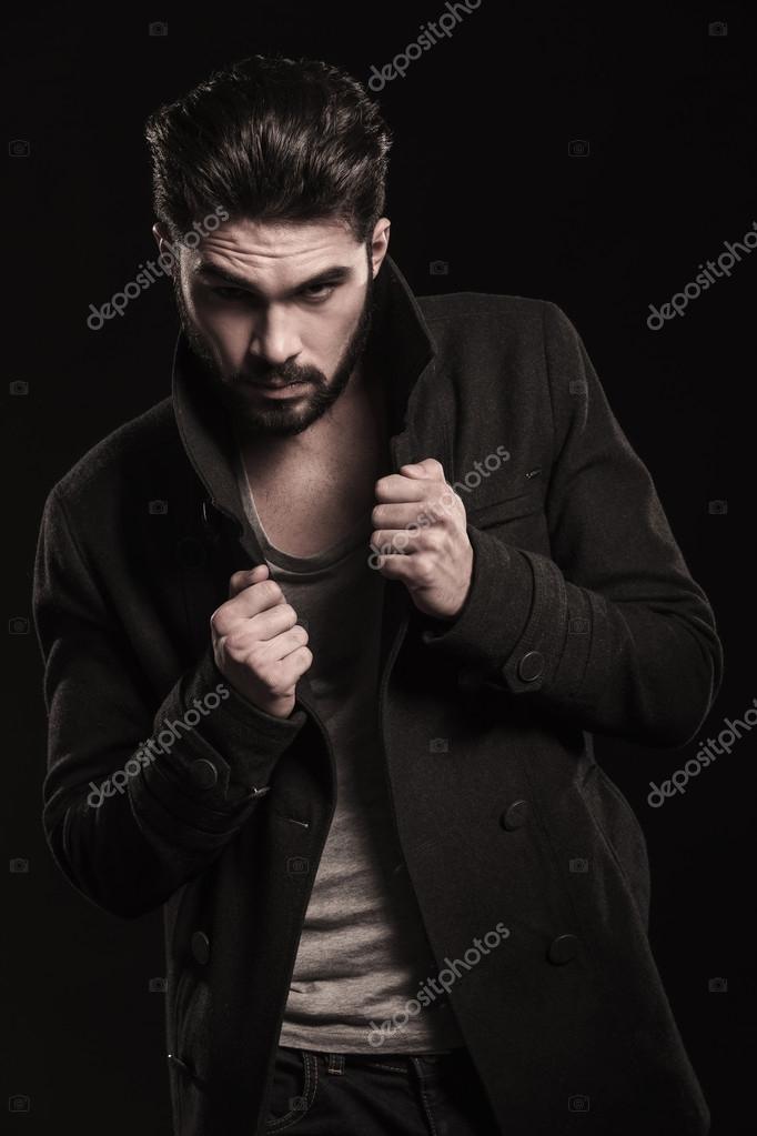 Serious fashion model pulling his collar and poses — Stock Photo ...