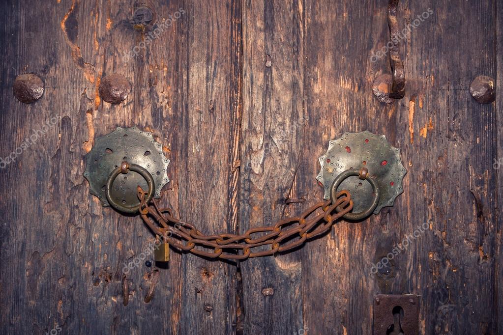 Closed lock with a chain on a wooden door Stock Photo by ©netfalls 40336585