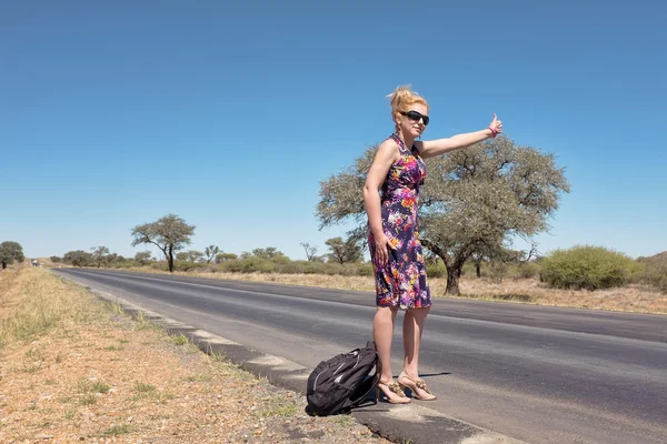 Young woman hitching a ride on lonely desert road Stock Photo by ©AVFC ...