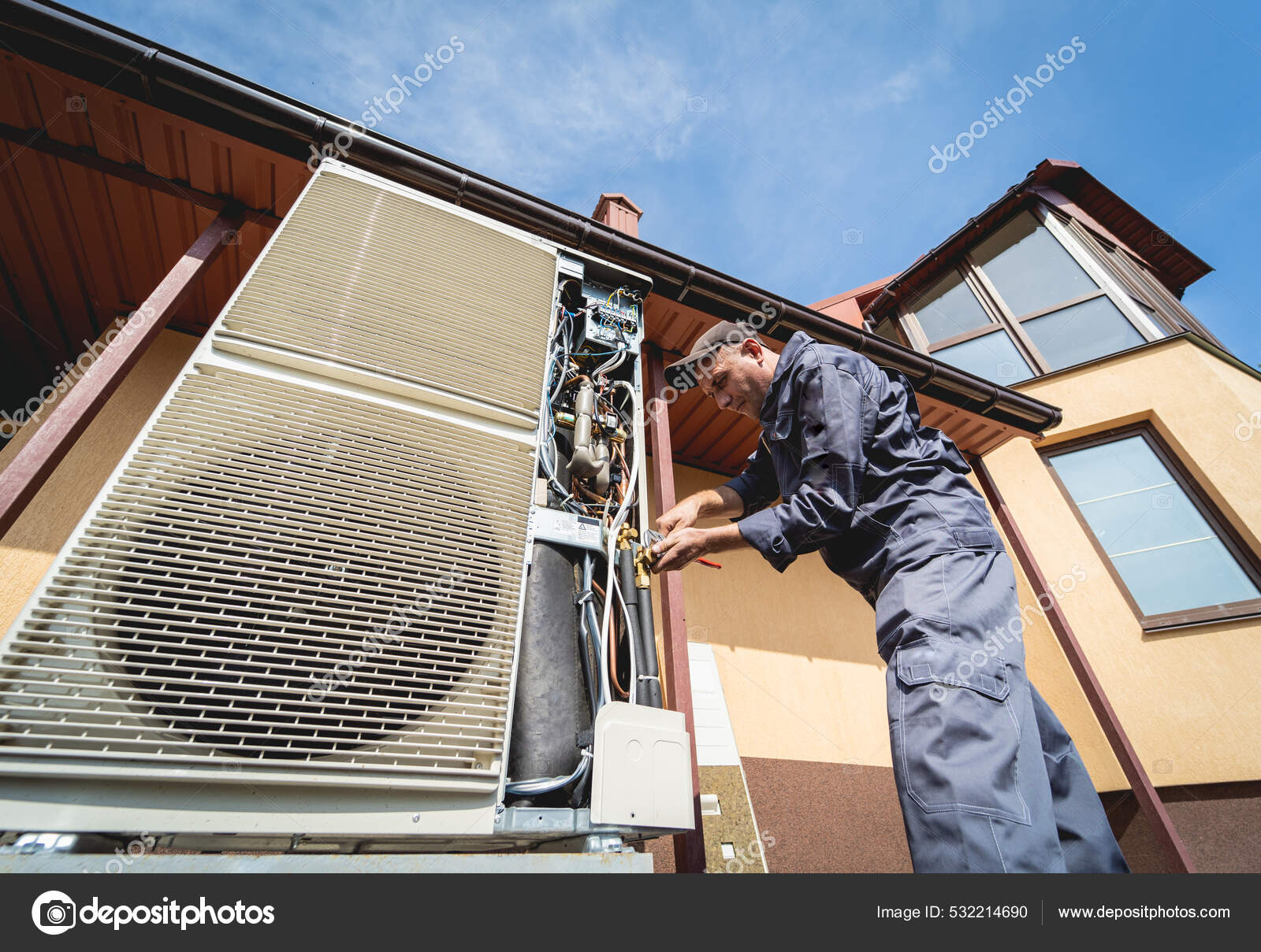 HVAC technician servicing home heating and cooling system Stock Photo ...