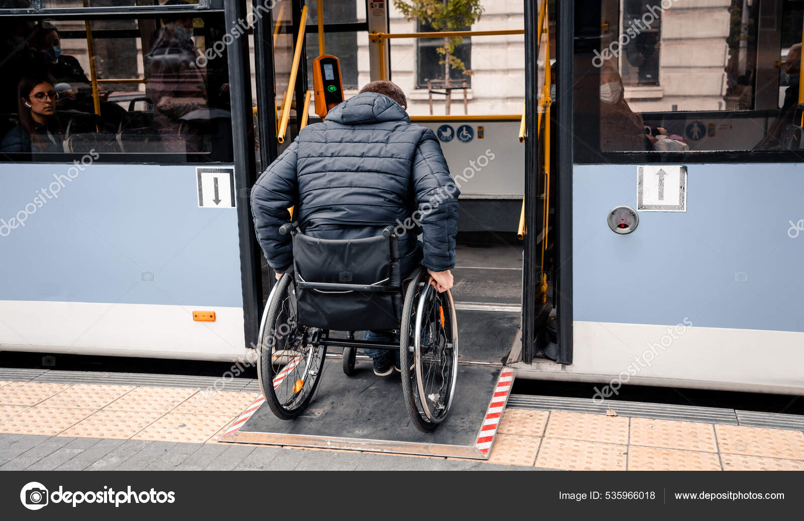 Person with a physical disability enters public transport with an ...