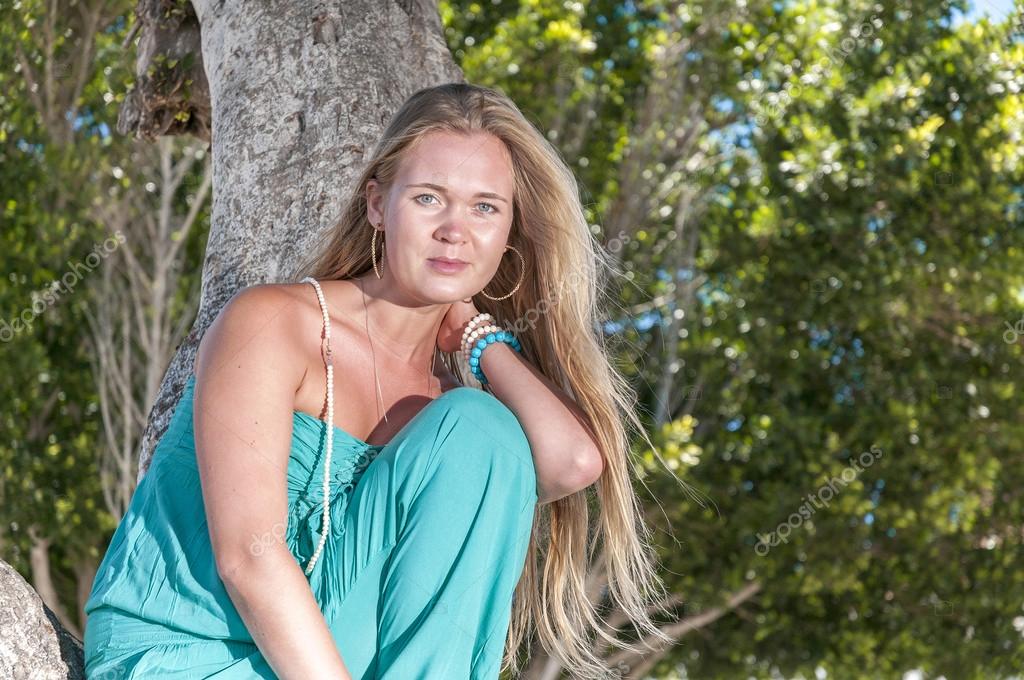 Beautiful young woman sitting on a tree trunk Stock Photo by ©Ninelle ...