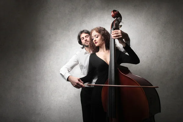Man, woman holding a double bass - Stock Image - Everypixel