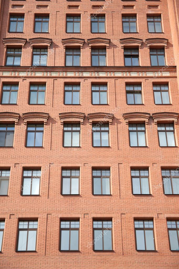 Front view of brick wall contemporary apartment building with windows ...
