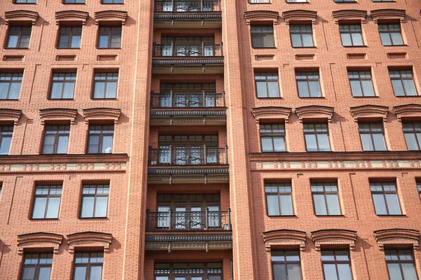 Front view of brick wall contemporary apartment building with balconies ...