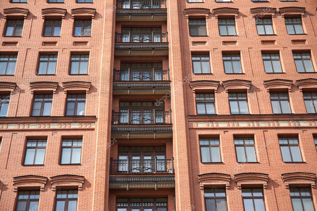 Front view of brick wall contemporary apartment building with balconies ...