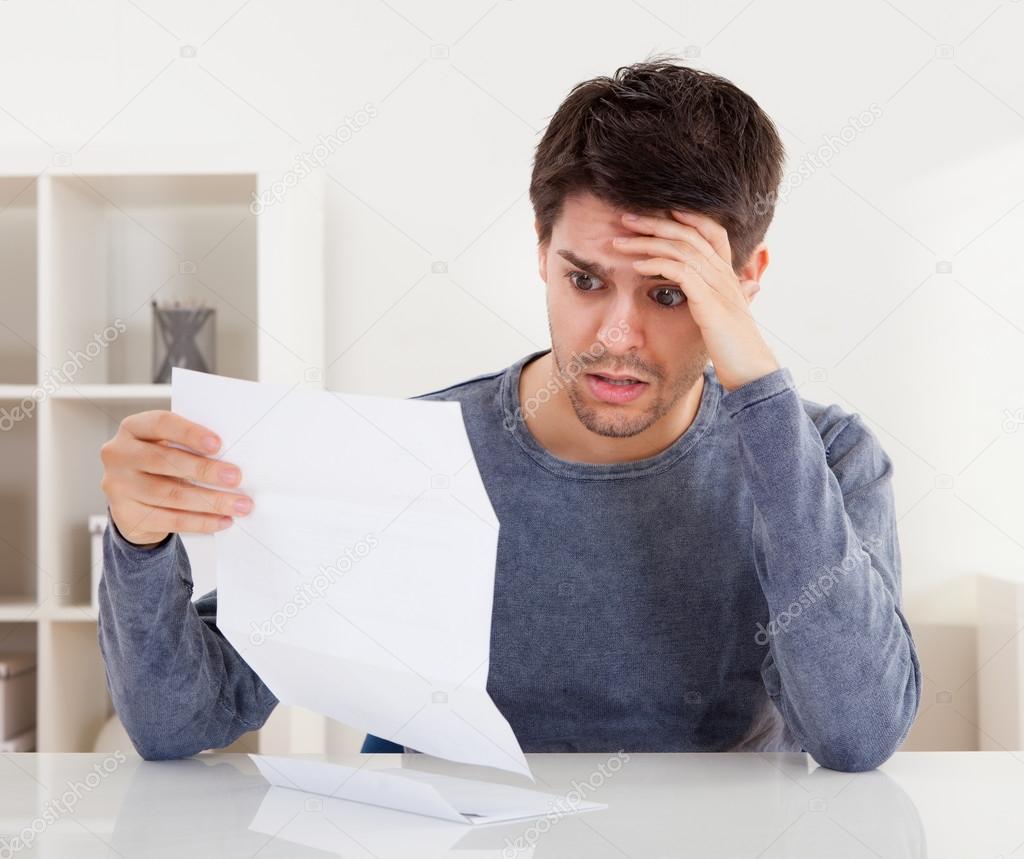 Horrified man reading a document Stock Photo by ©AndreyPopov 18927497