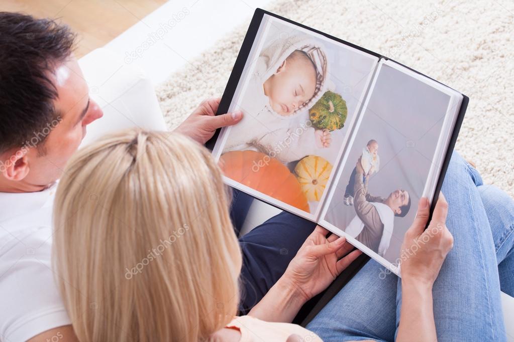 Couple Looking At Album — Stock Photo © AndreyPopov #28062305