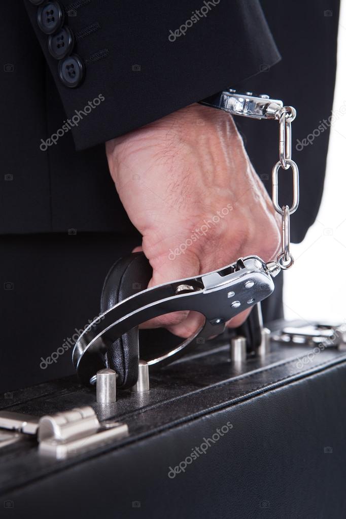 Hand With Handcuff Holding Suitcase Stock Photo by ©AndreyPopov 39412315