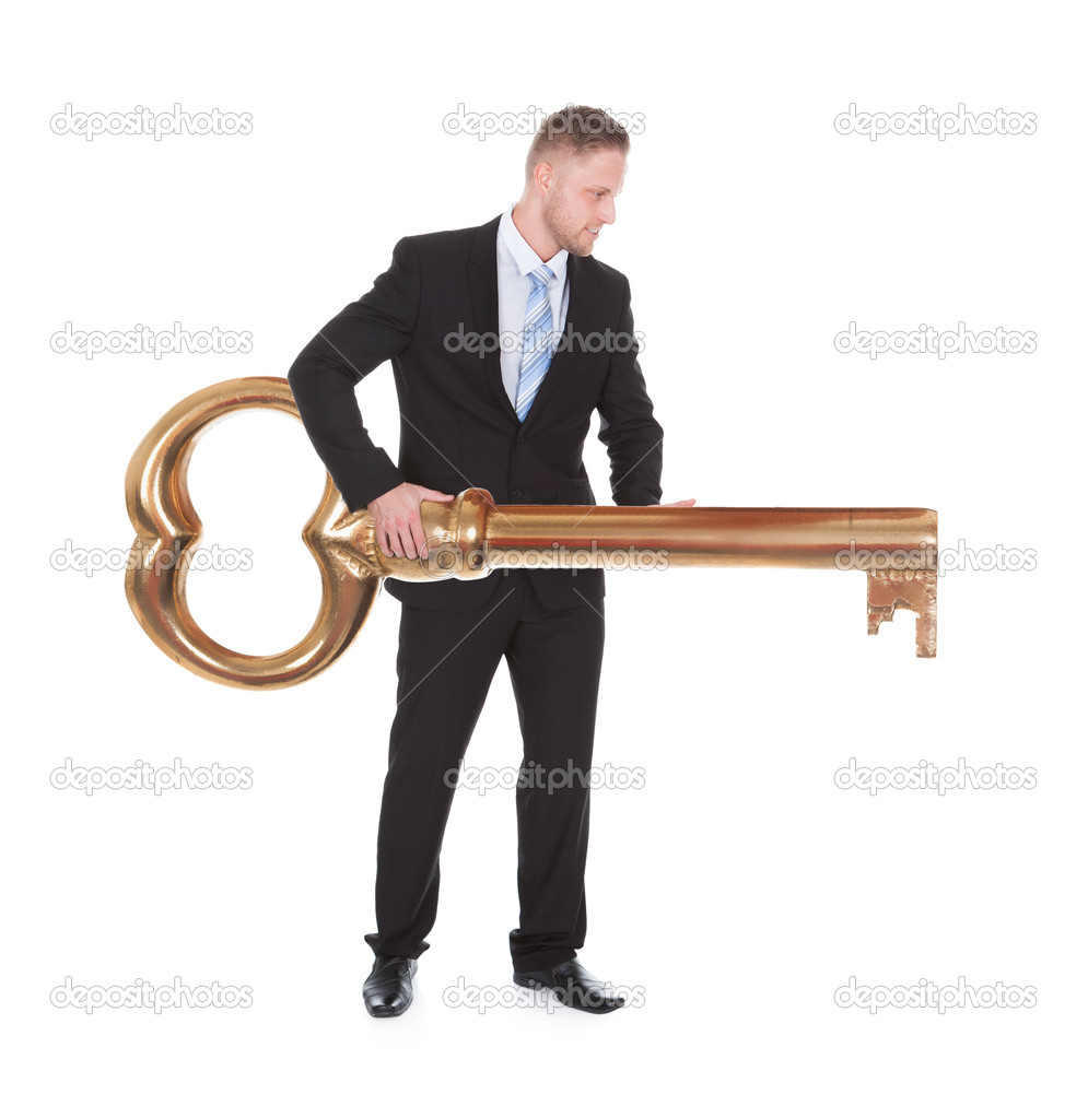 Businessman carrying a large brass key — Stock Photo © AndreyPopov ...