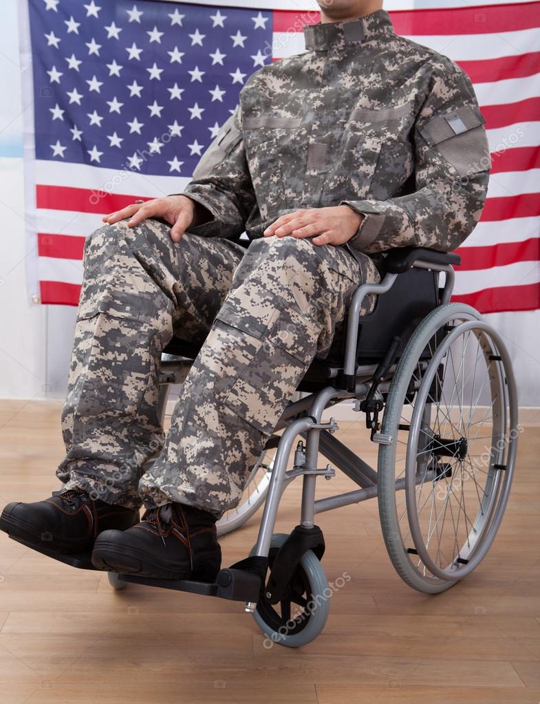 Patriotic Soldier Sitting On Wheel Chair Against American Flag Stock ...
