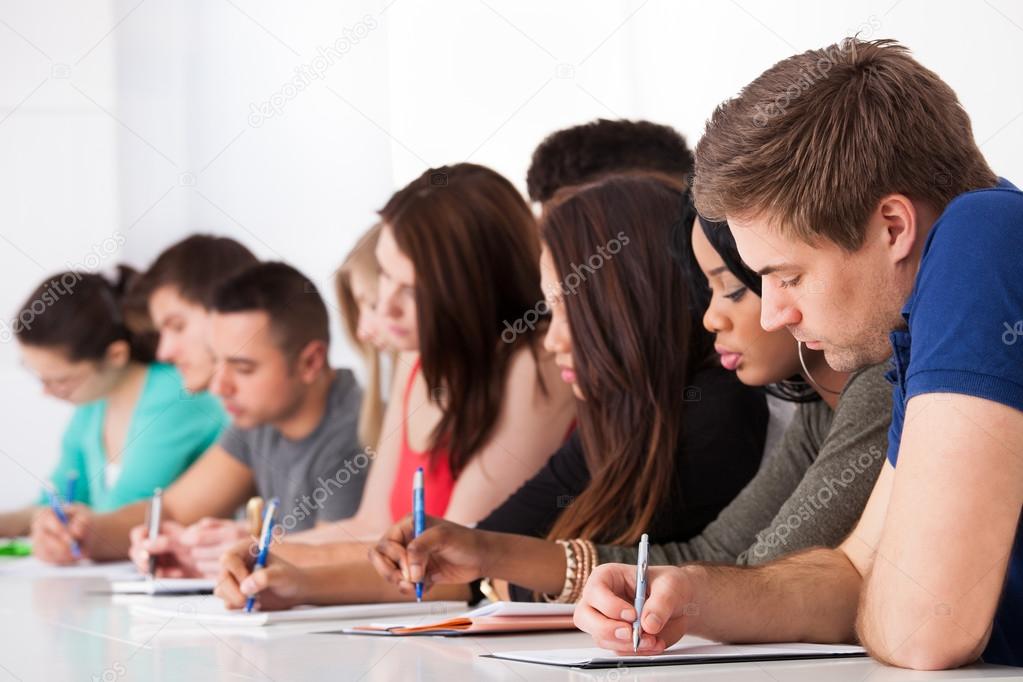 Row Of College Students Writing At Desk — Stock Photo © AndreyPopov ...