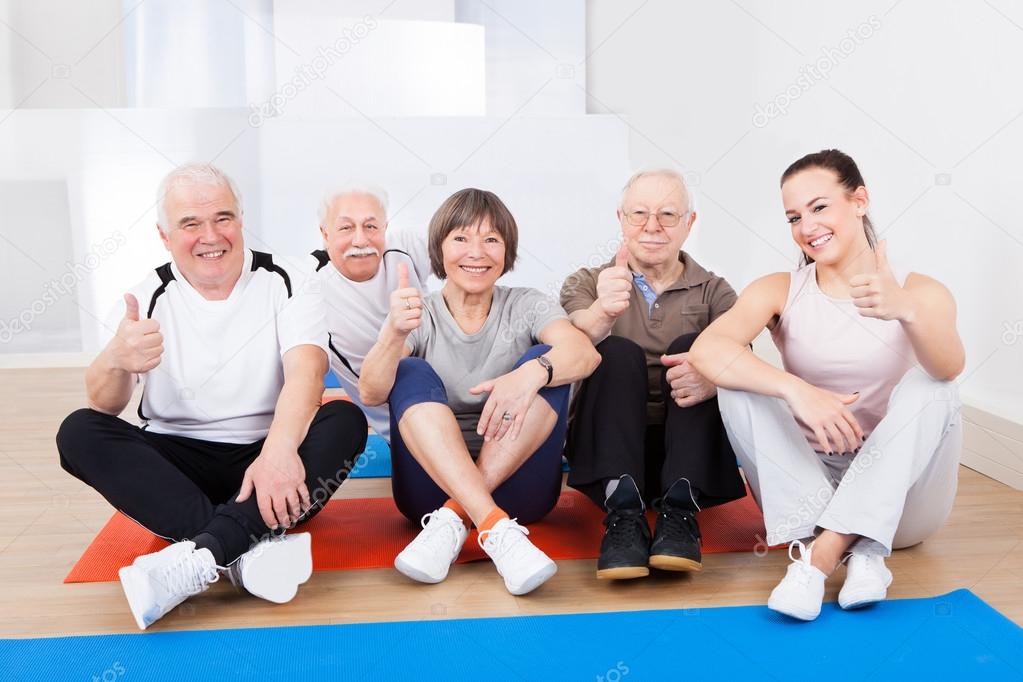 Female Trainer With Senior Customers At Gym — Stock Photo © AndreyPopov ...