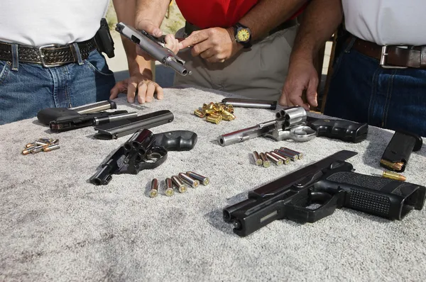 Three Men With Guns On Table — Stock Photo © londondeposit #21959225