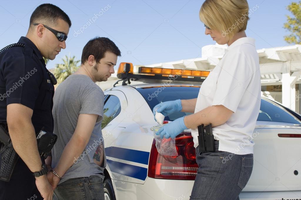 Police Officer Arresting Young Man — Stock Photo © londondeposit #21800435