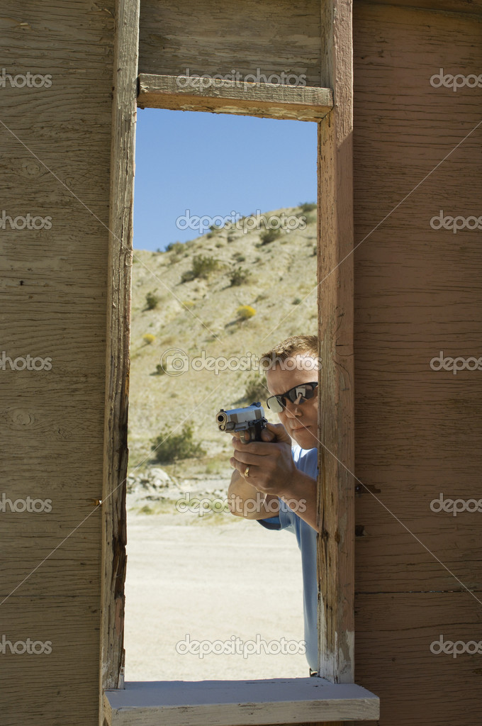 Man Aiming Hand Gun At Firing Range — Stock Photo © londondeposit #21801625