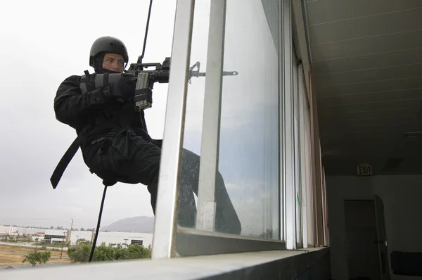SWAT Team Officer Rappelling and Aiming Gun Stock Photo by ...