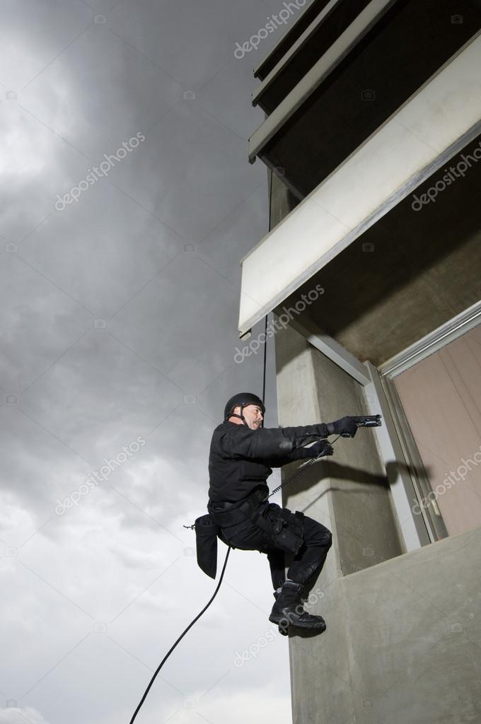 SWAT Team Officer Rappelling and Aiming Gun Stock Photo by ...