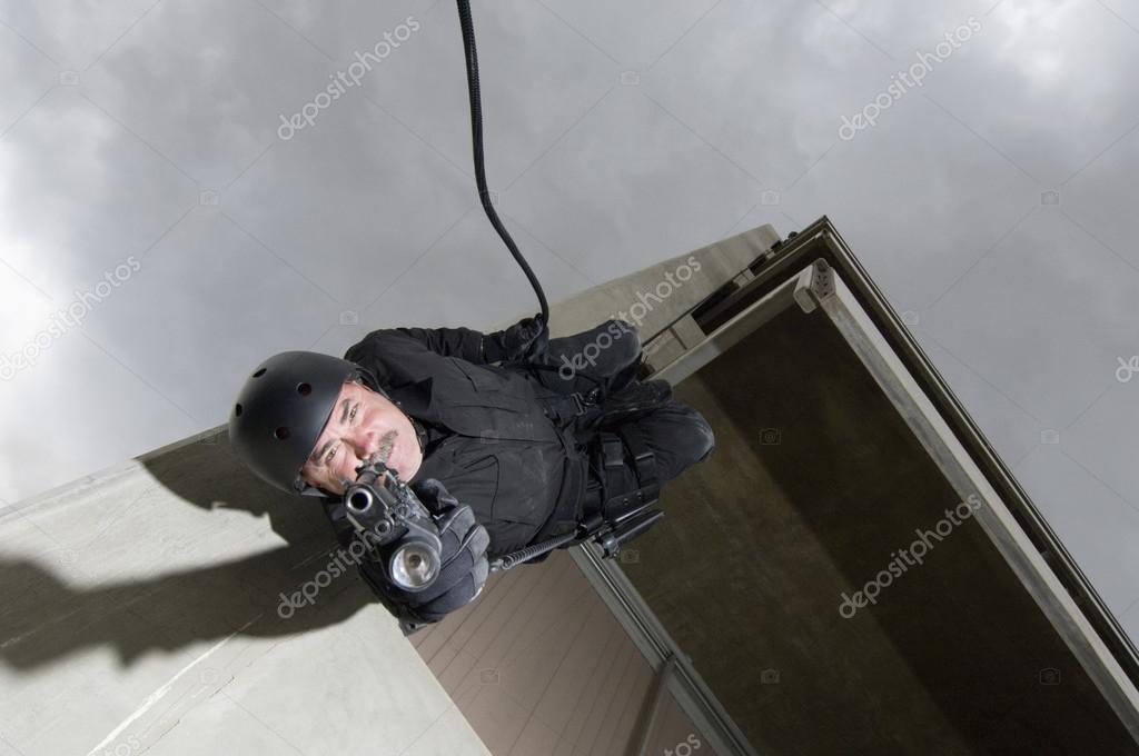 SWAT Team Officer Rappelling and Aiming Gun Stock Photo by ...