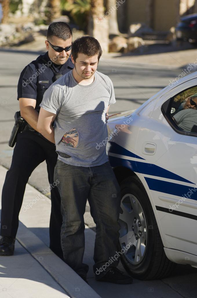 Police Officer Arresting Young Man Stock Photo by ©londondeposit 21958331