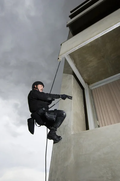 SWAT Team Officer Rappelling and Aiming Gun Stock Photo by ...