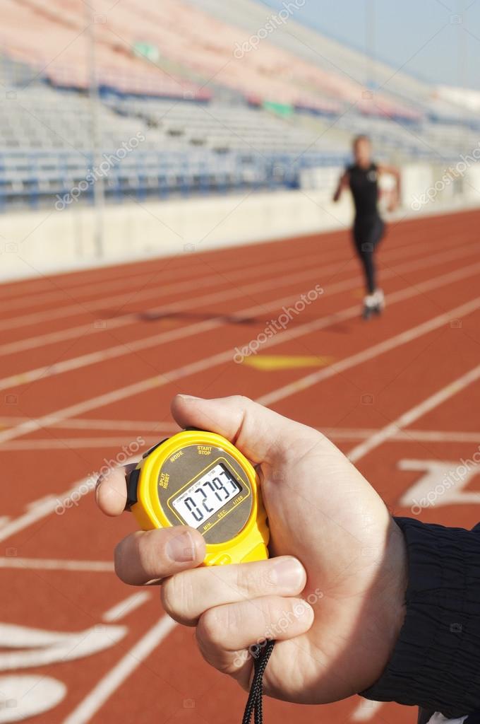 Hand holding stopwatch Stock Photo by ©londondeposit 33803051