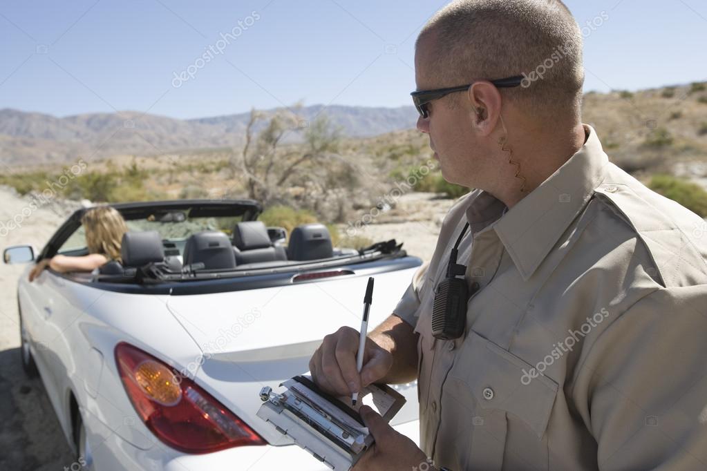 Police officer writing traffic ticket — Stock Photo © londondeposit ...