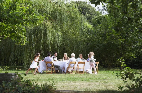 Family eating at table in garden - Stock Image - Everypixel