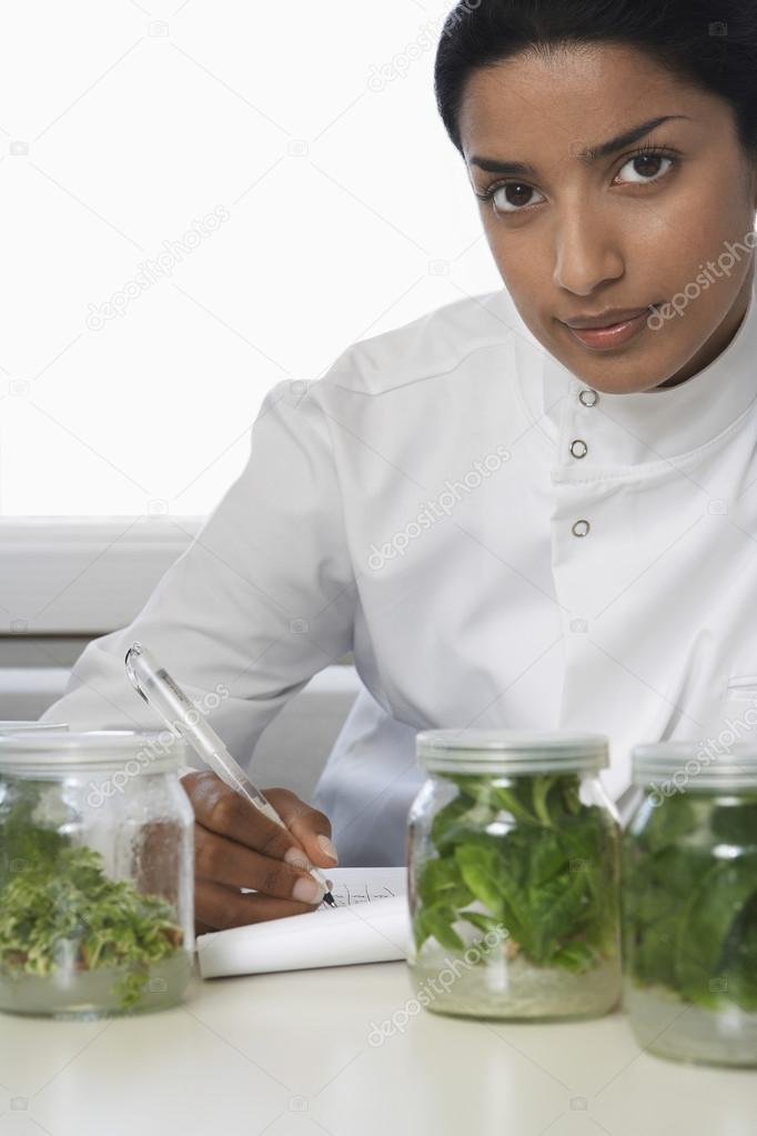 Lab worker with plants material Stock Photo by ©londondeposit 33841107